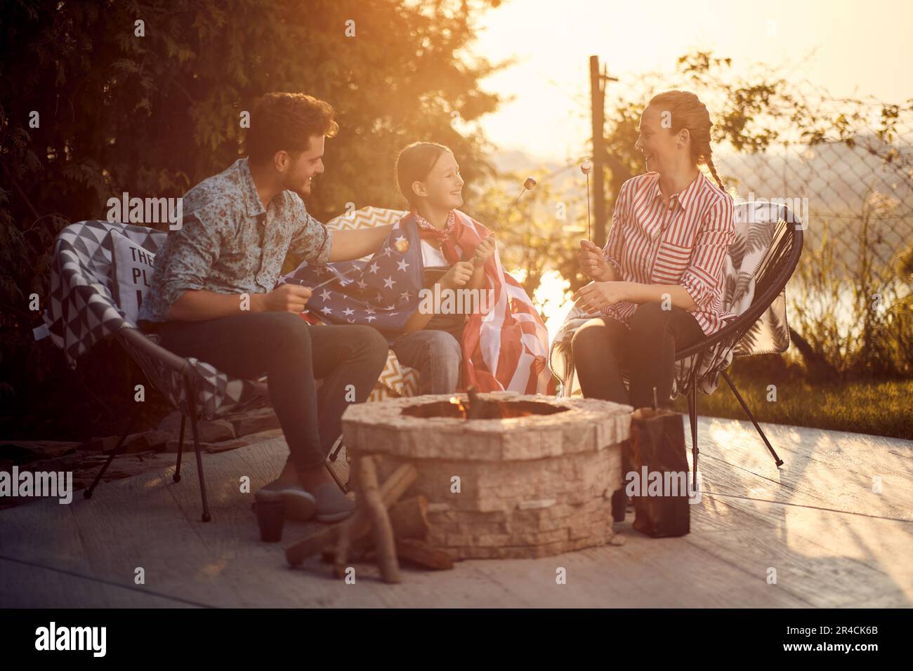 Family gathers around a crackling fire, joyfully roasting marshmallows ...