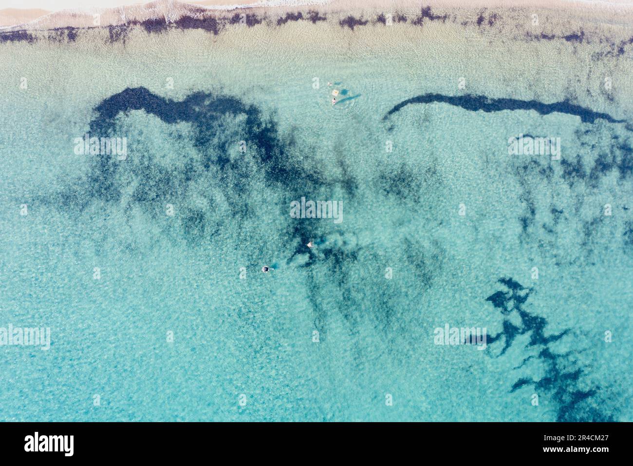 People swim in transparent shallow and deep blue Aegean sea water ...