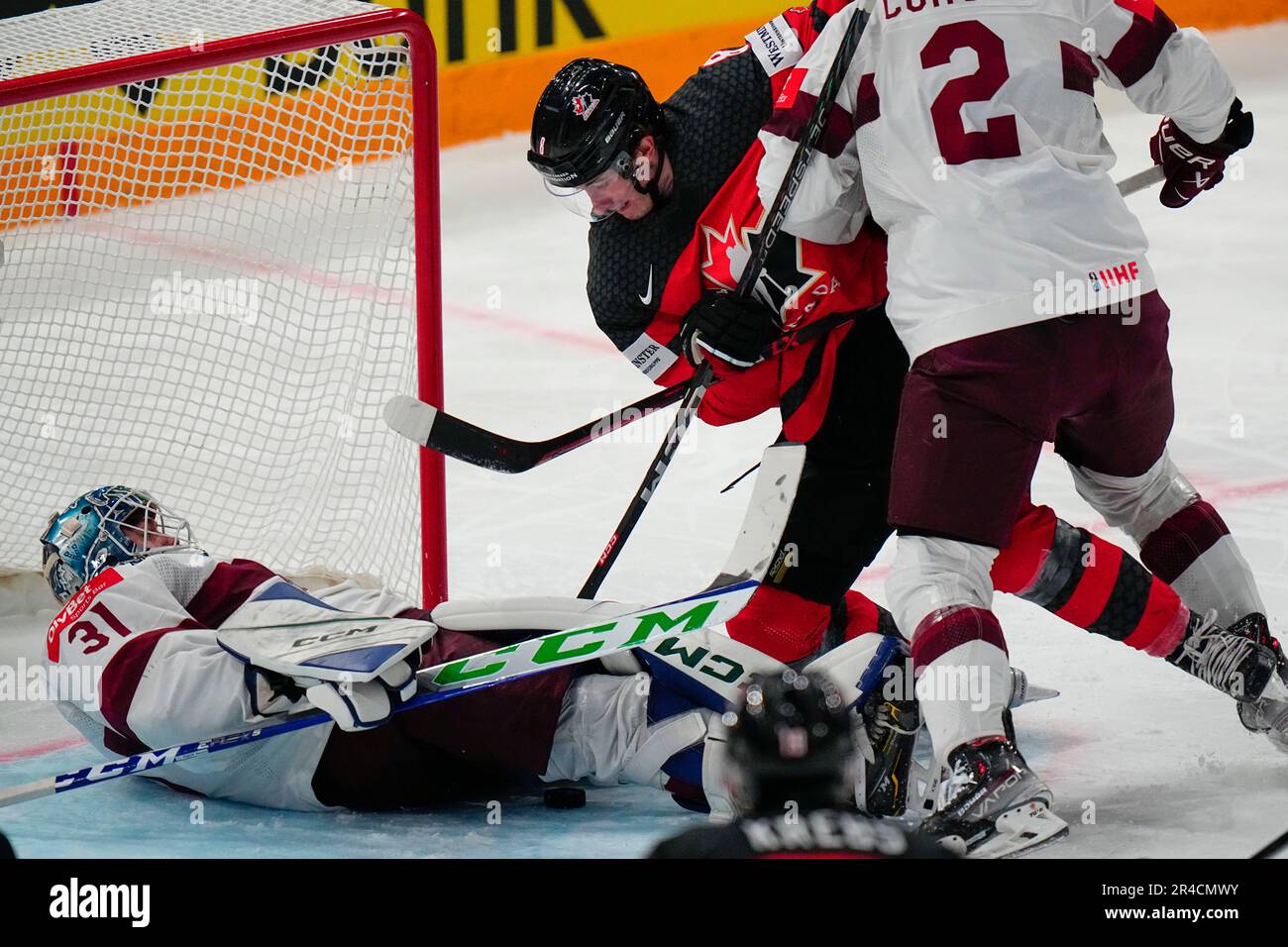 Latvia's goalie Arturs Silovs (31) falls to the ice while battling ...