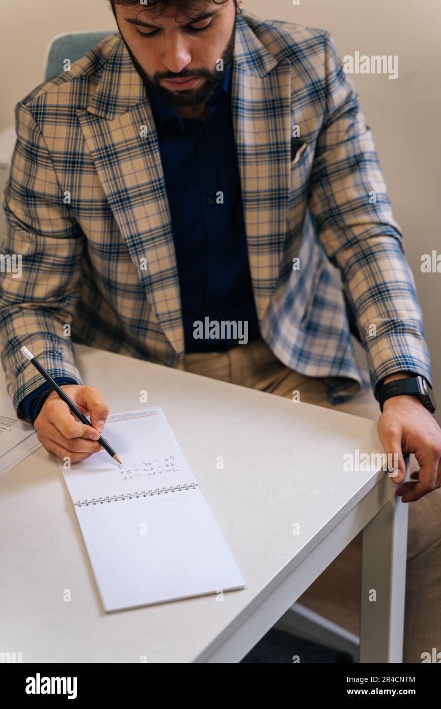 A young good looking accountant calculating something Stock Photo - Alamy