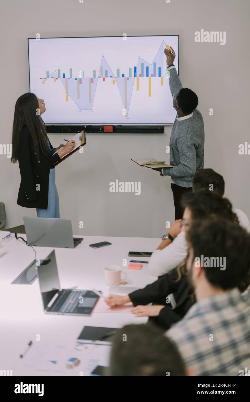Black male and white female people, couple, explaining graph charts on ...