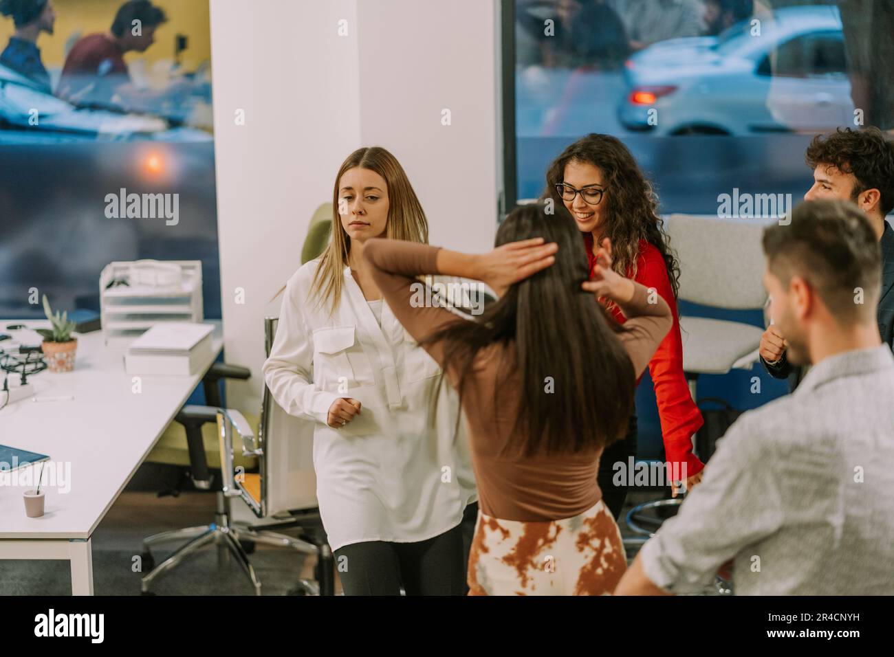A group of young colleagues dancing at modern office. Celebrating ...