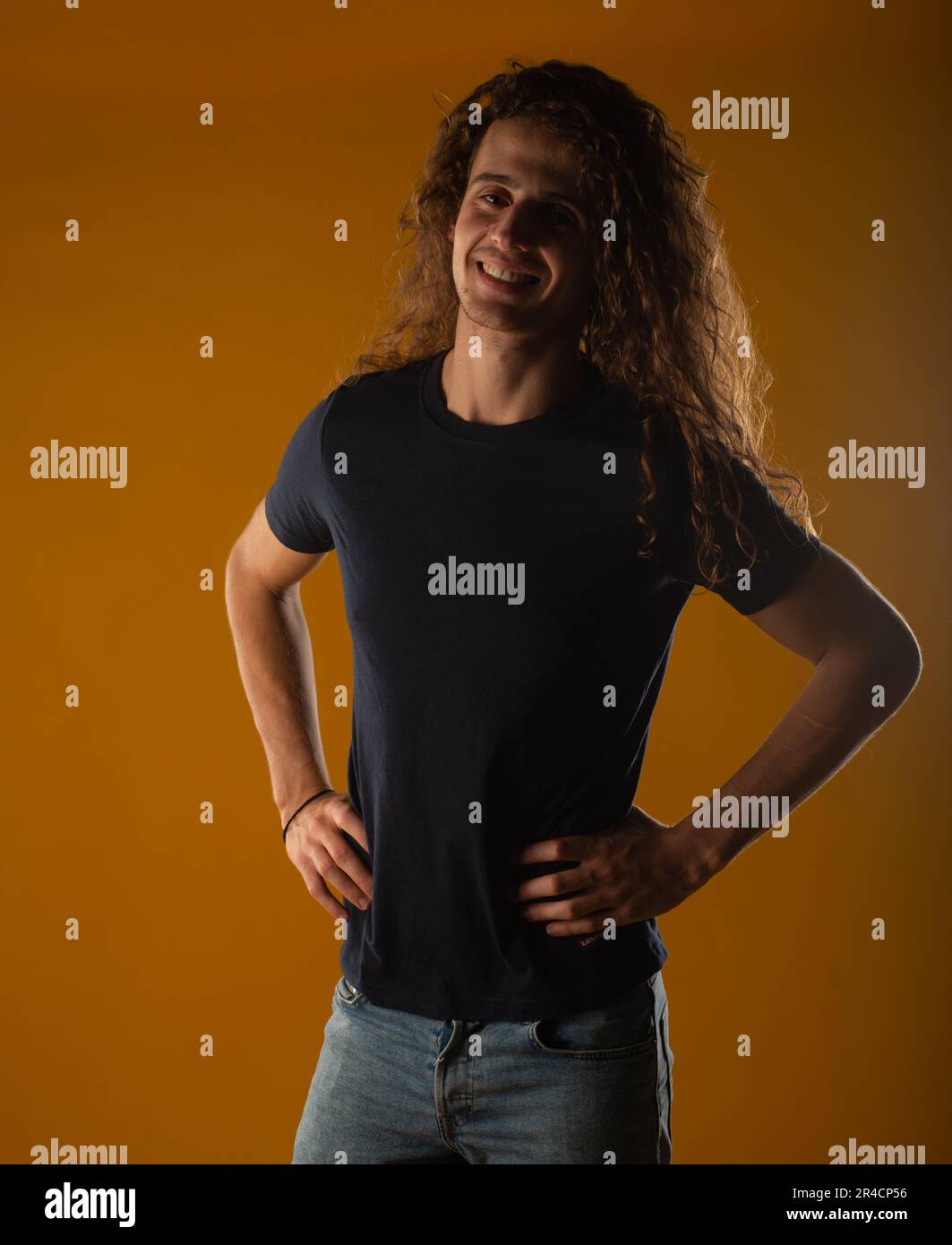 Smiley handsome guy posing in studio with the hands on his spine Stock ...