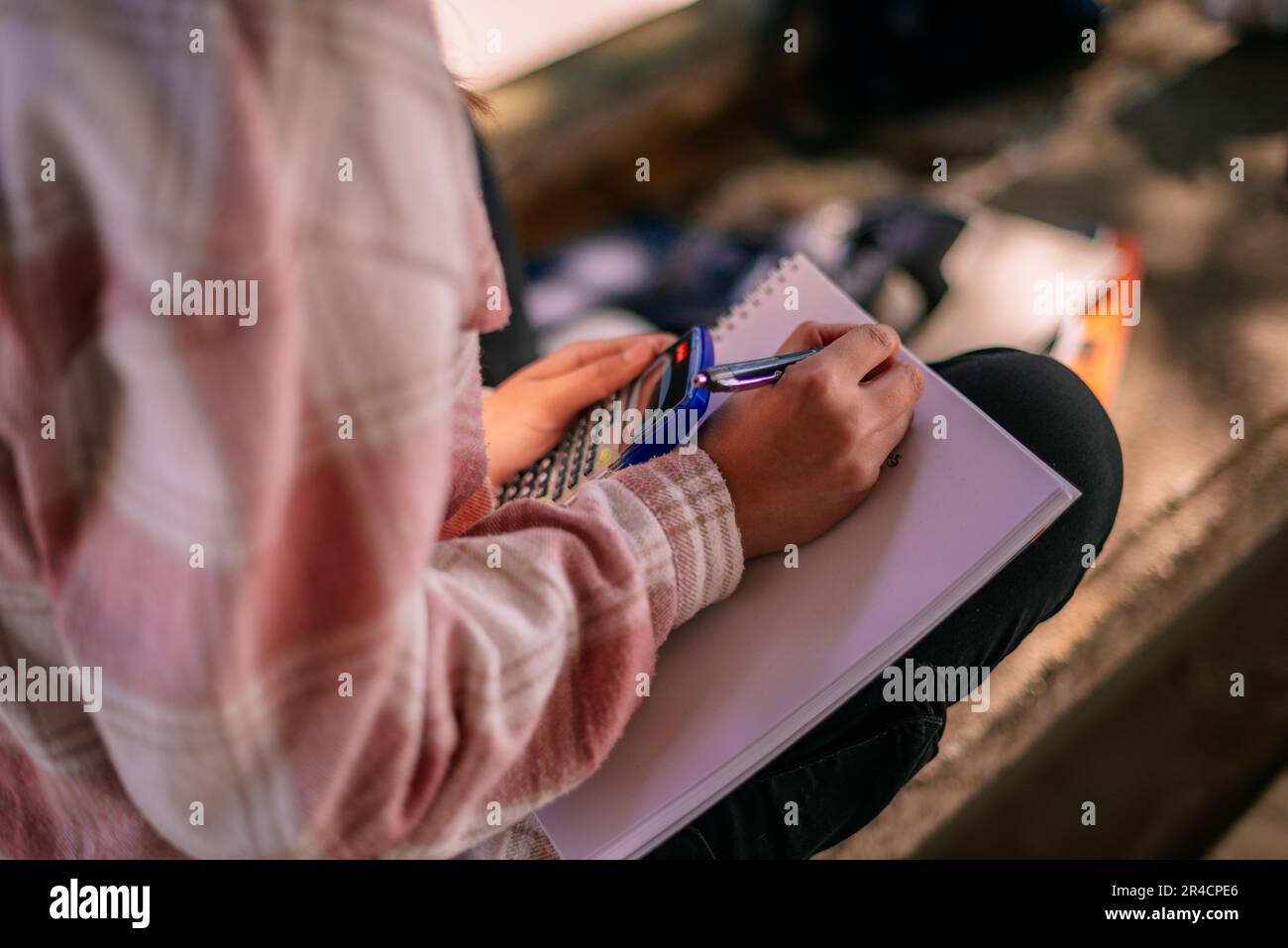 School girl writing homework. She is calculating mathematics task ...