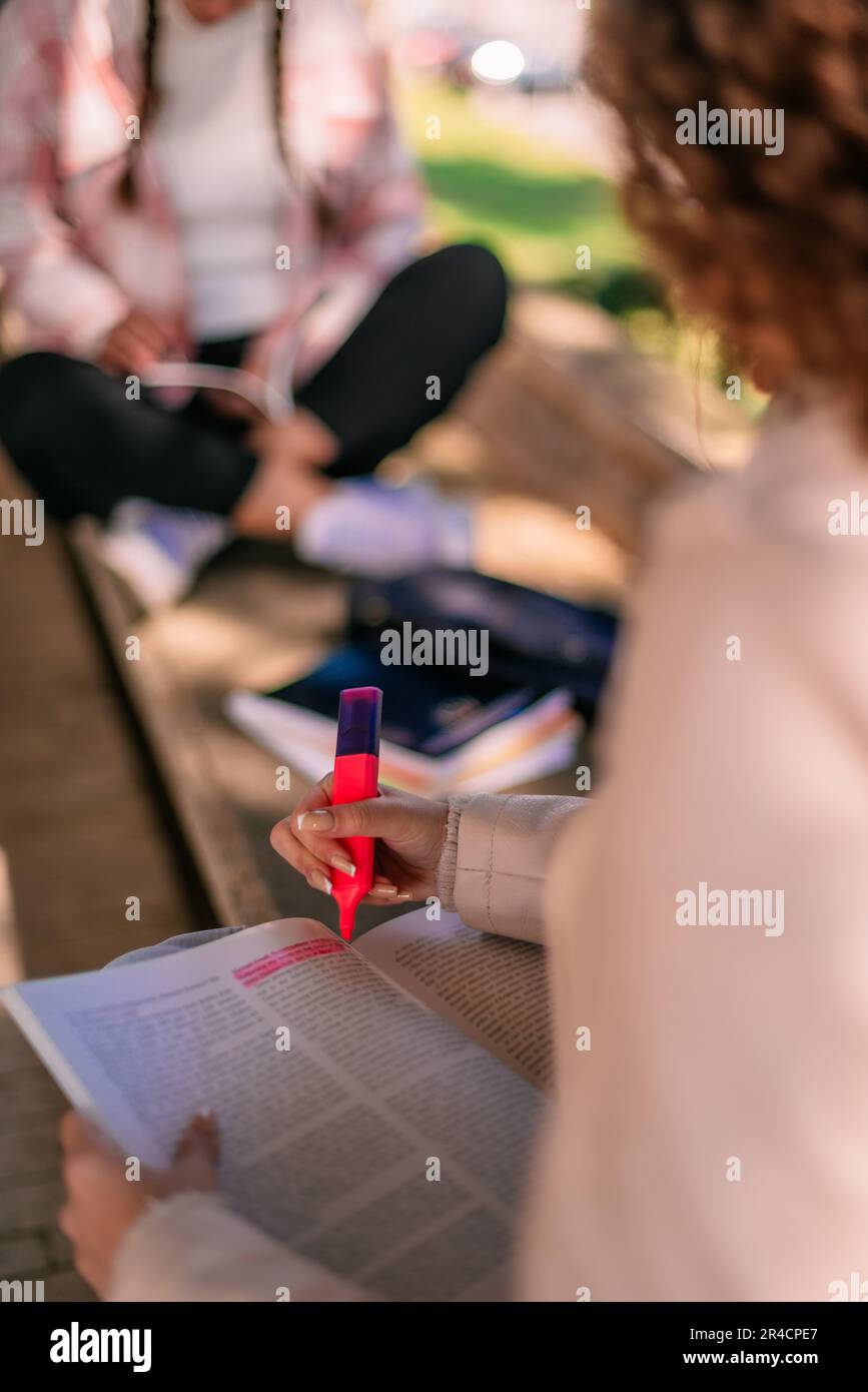 School girl underlining important parts of the book for the next exam ...