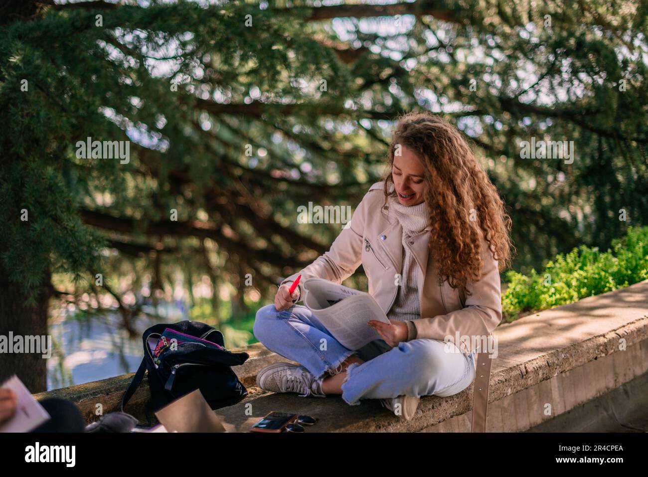 Curly haired girl studying before exam. She is reading a book out loud ...