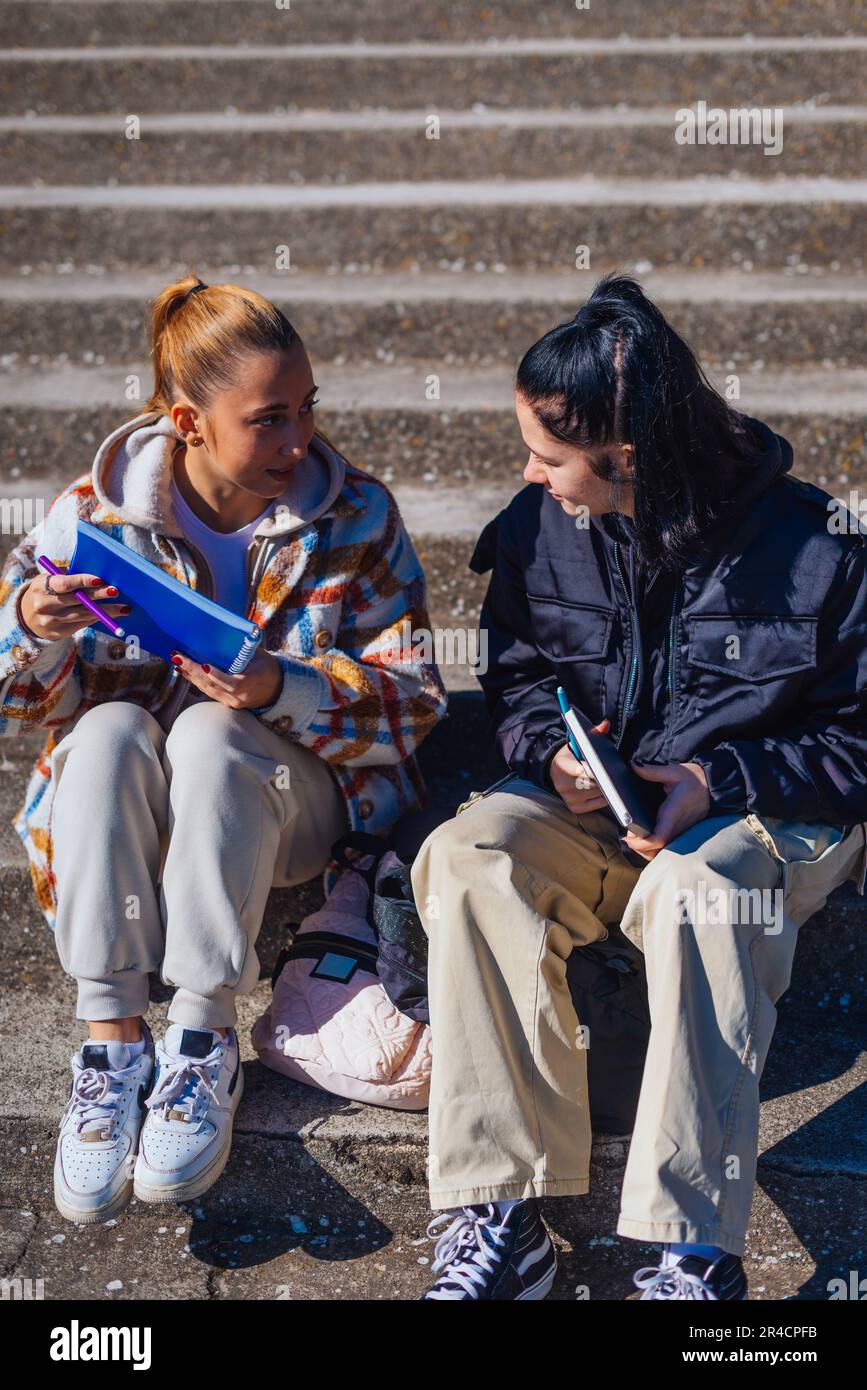 Young innocent high school girls are sitting on the stairs after school ...