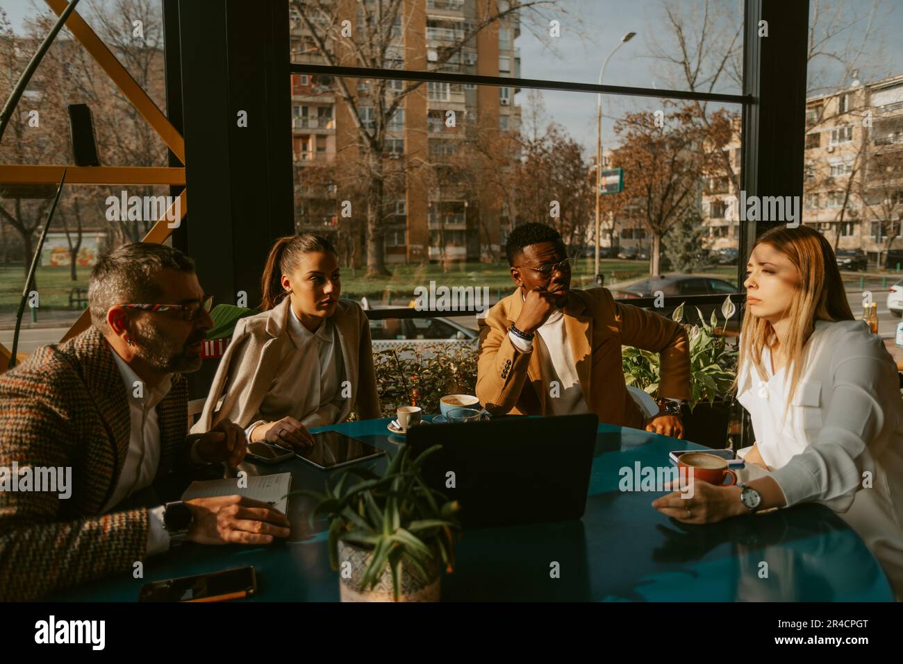 Four business people having a business meeting while sitting at the ...