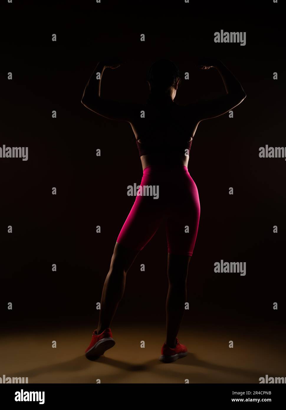 A back view photo of strong woman posing in studio on a beige ...