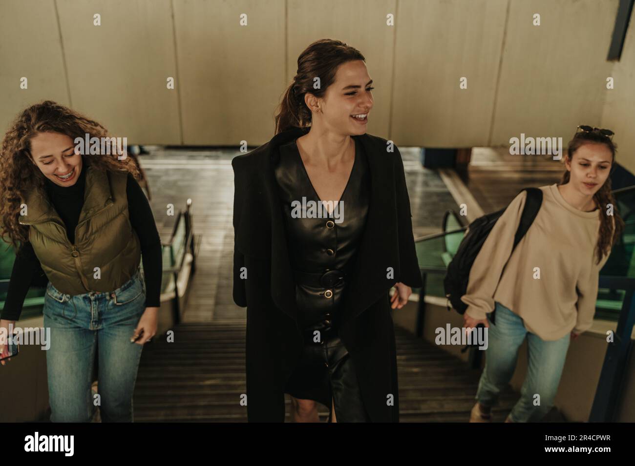 Three girls walking upstairs and laughing. Close up shot Stock Photo ...