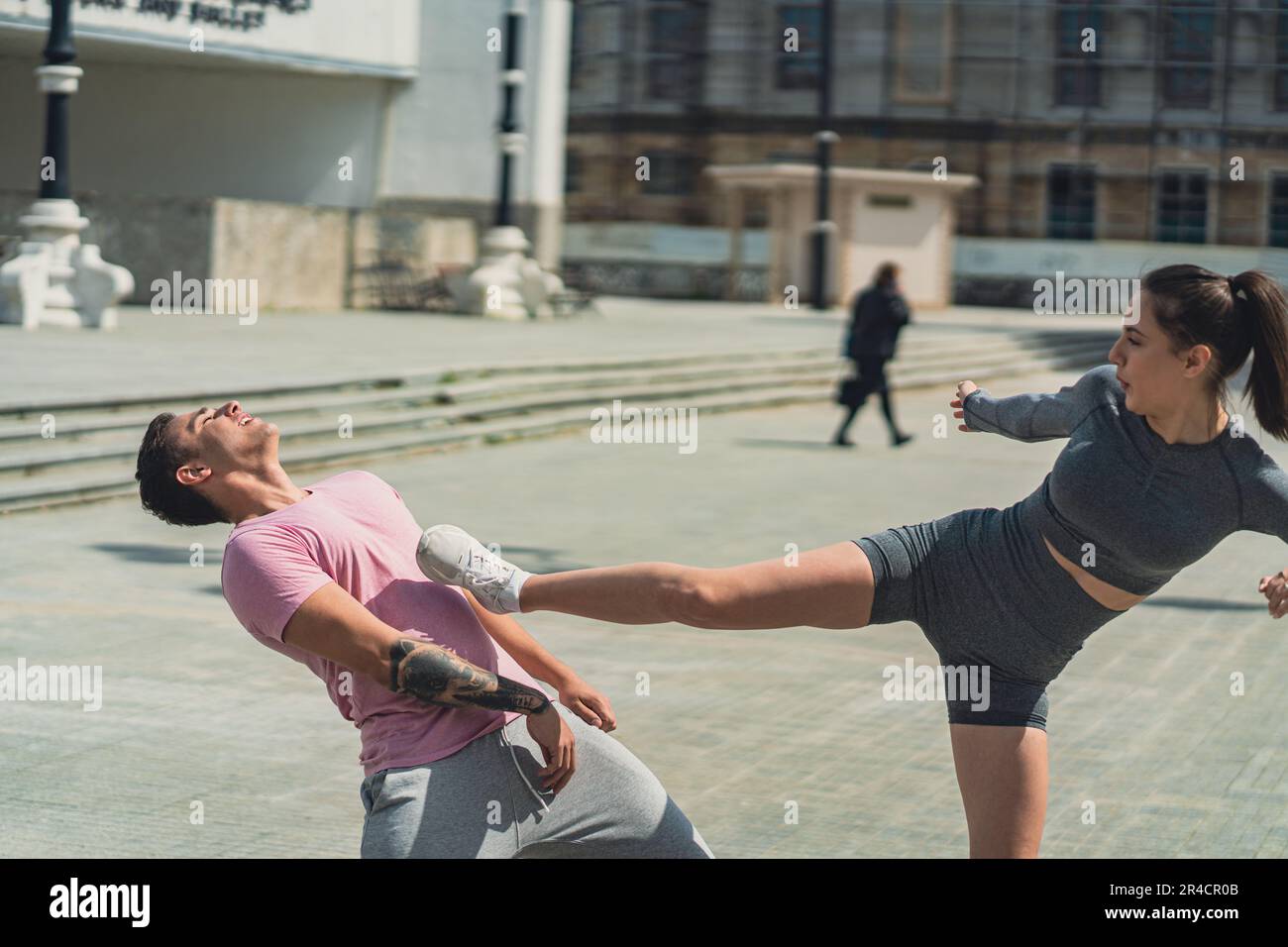 Lovely sportsgirl training with her male partner. She kicked him in the body with her leg Stock ...