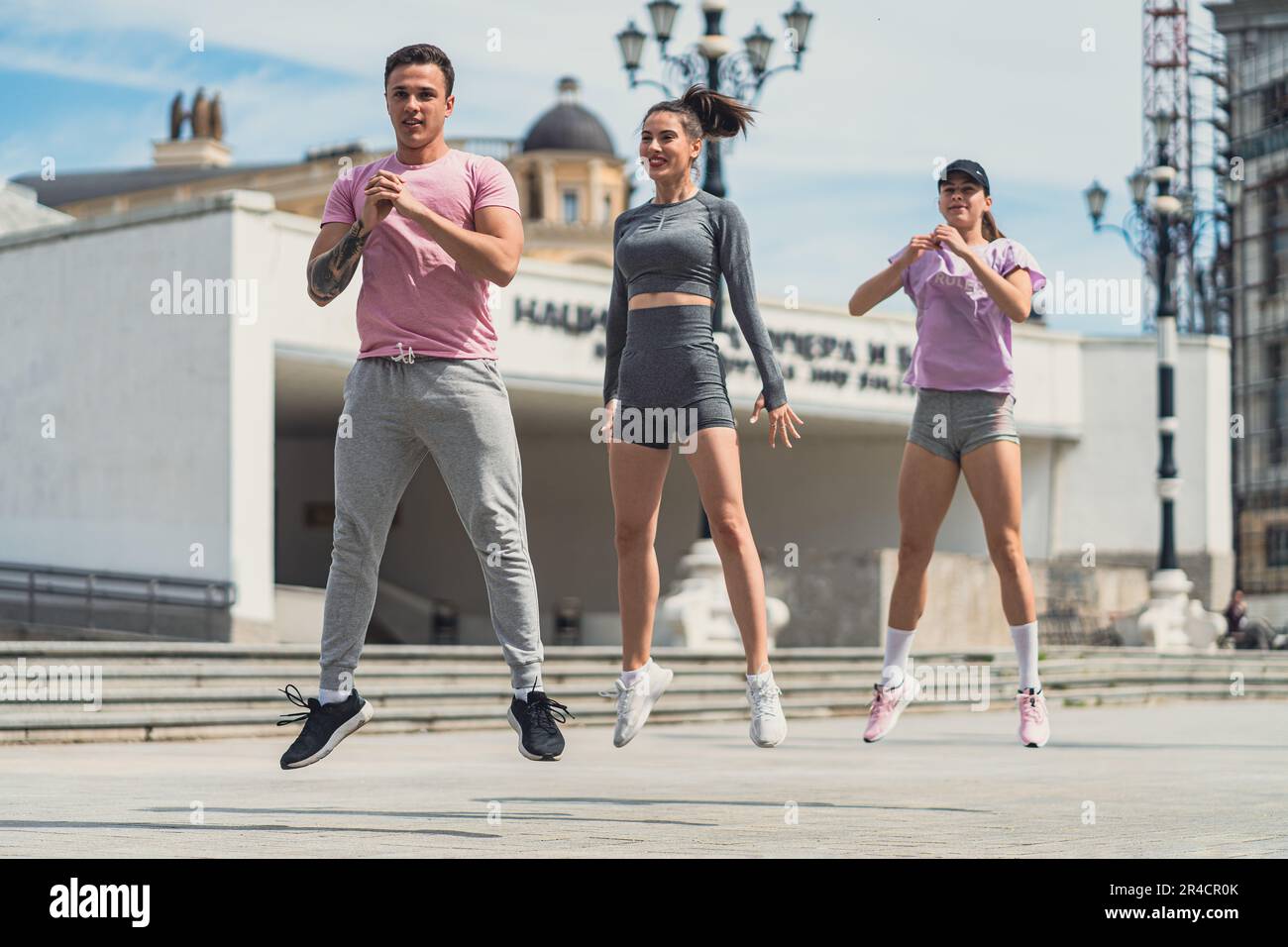 Stunning, fit sports friends jumping and doing squats at the same time ...