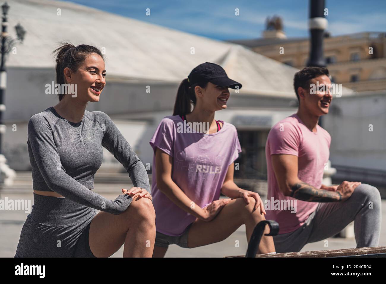 Lovely sportspeople saw something funny and smiling while stretching ...