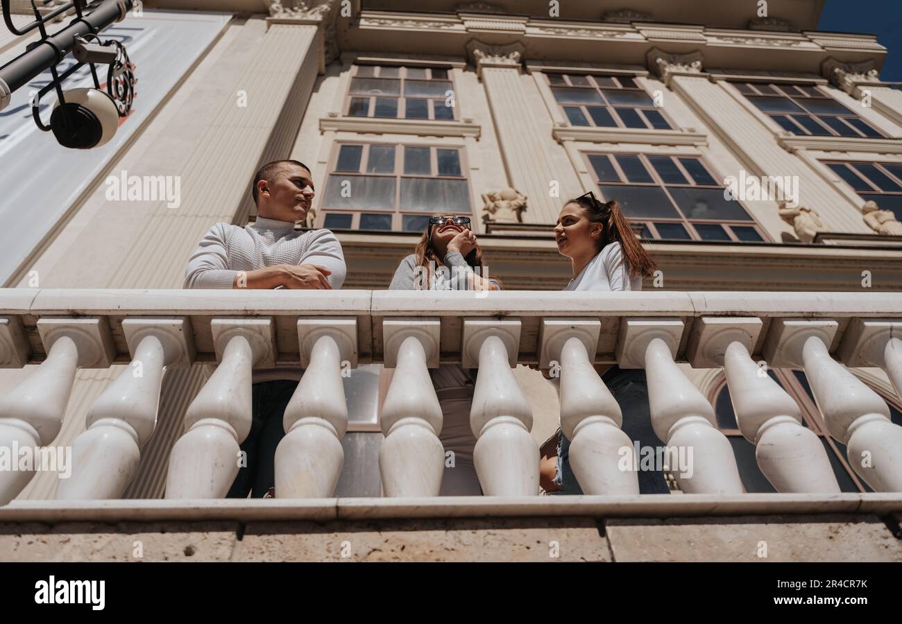 Three best friends talking while leaning on the fence in front of the ...