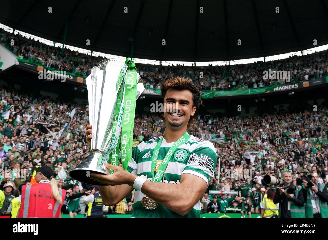 Celtic's Jota celebrates with the league trophy after the cinch ...