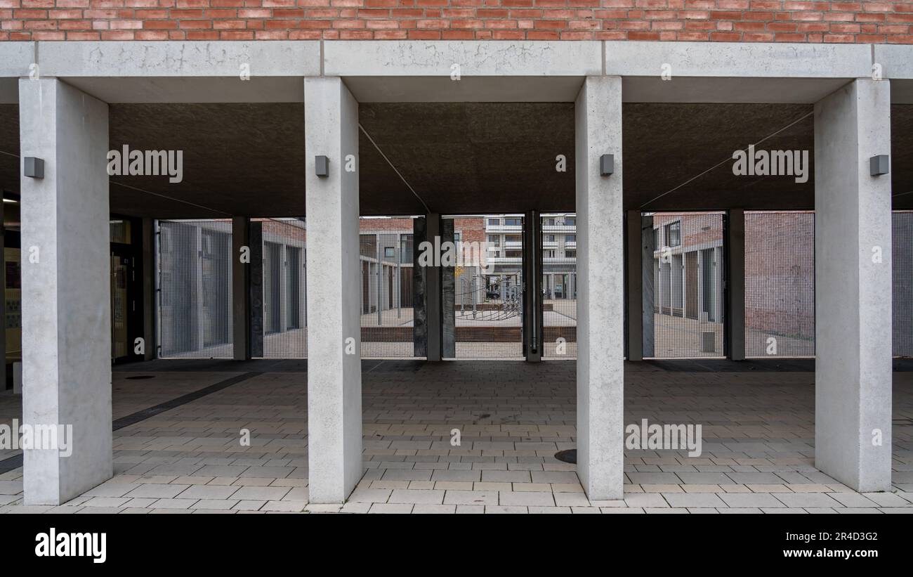A pathway made of red brick heads towards a brick building with white ...