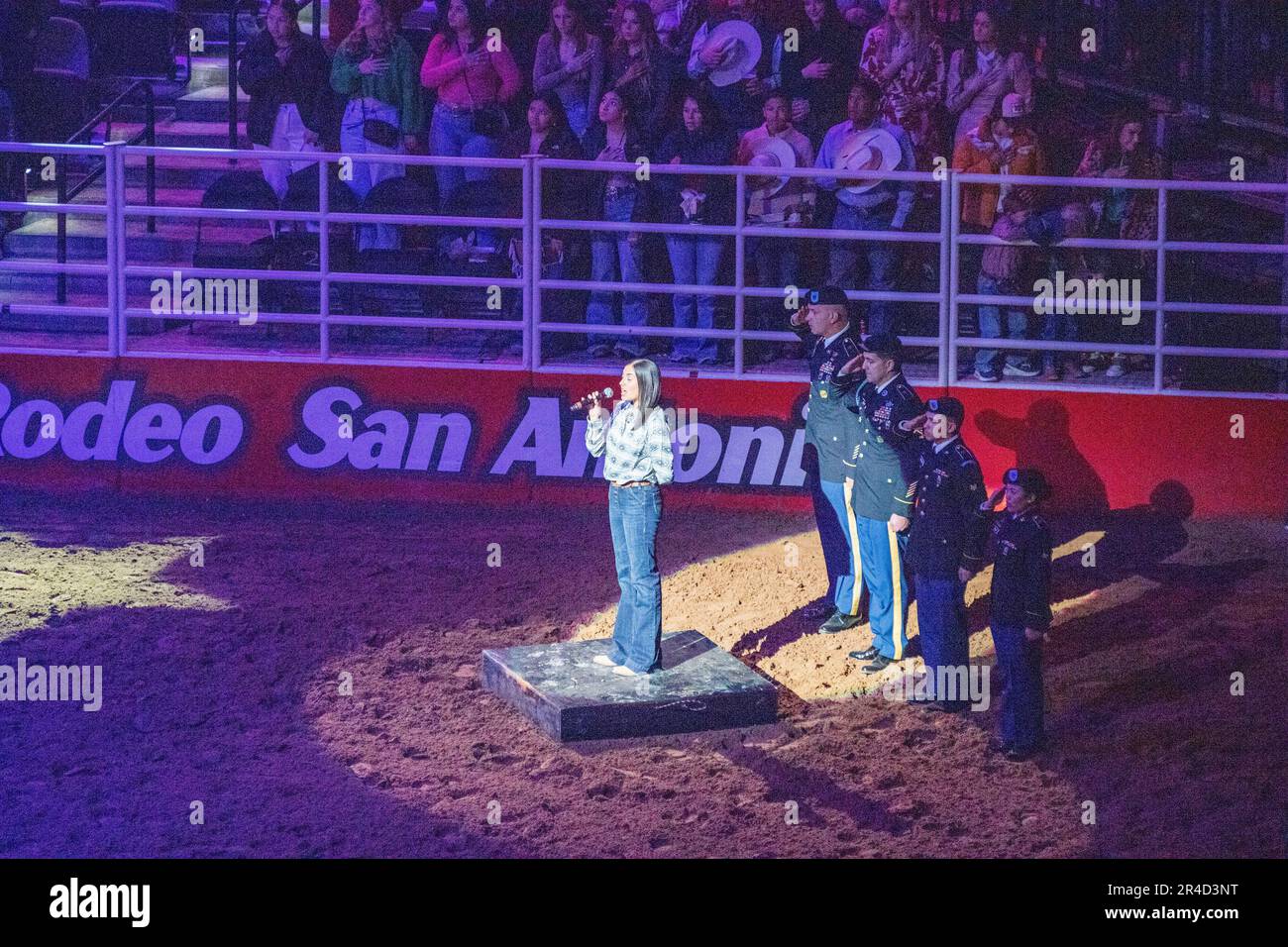 U.S. Army Soldiers salute while a volunteer sings the National Anthem ...
