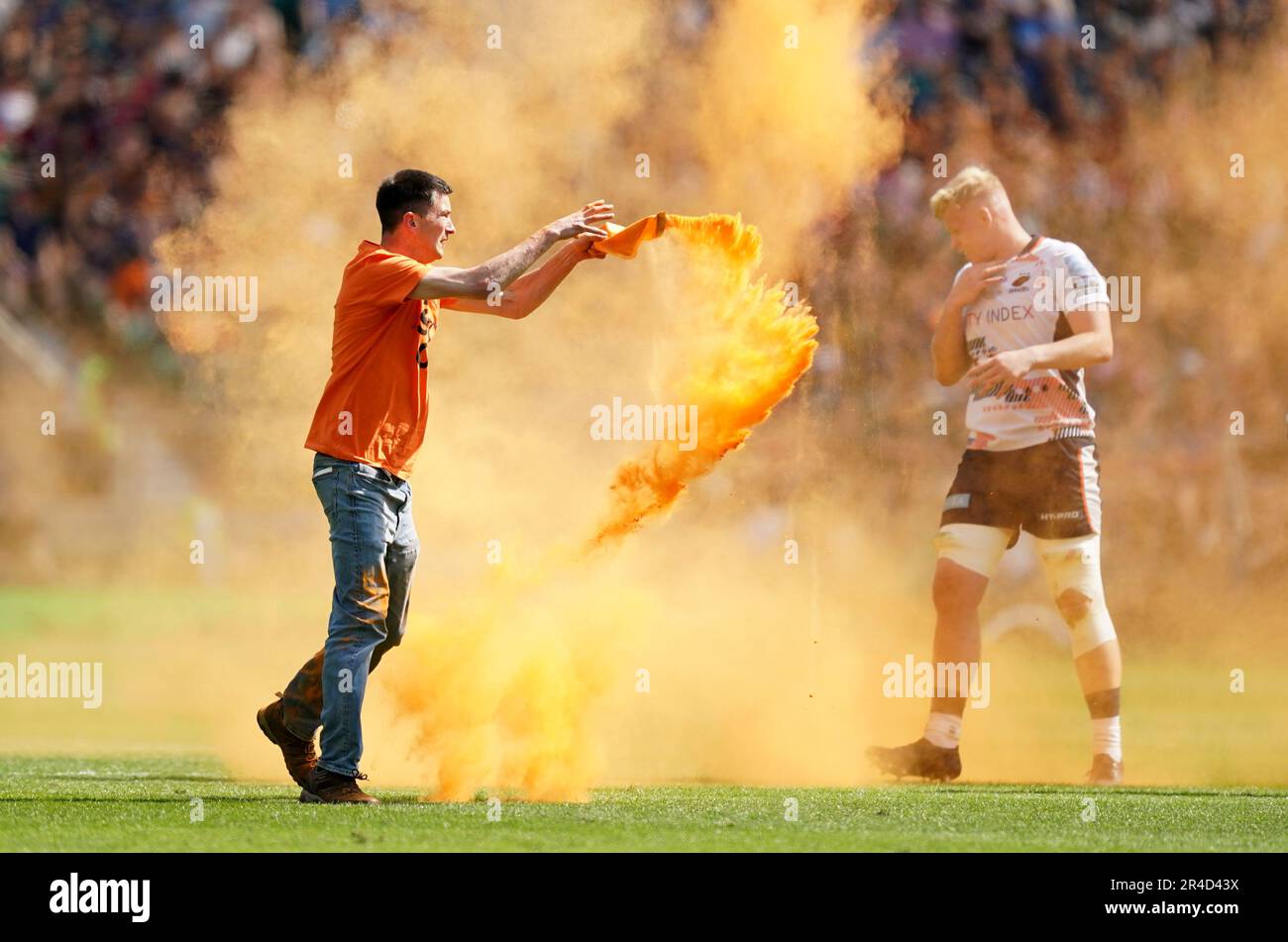 A Just Stop Oil protester throws orange powder on the pitch during the ...