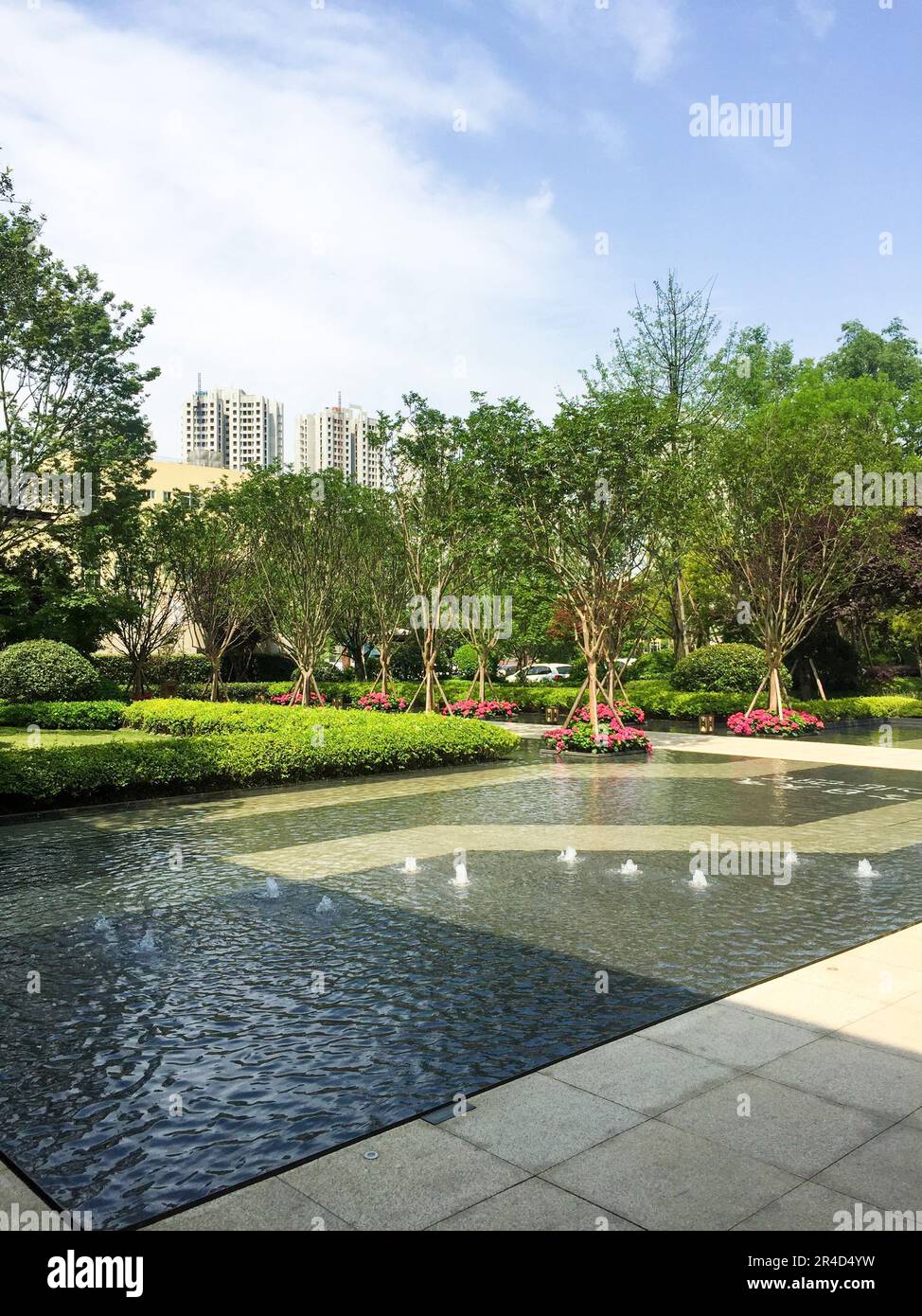A paved pathway with an open walkway and water feature flowing from a ...