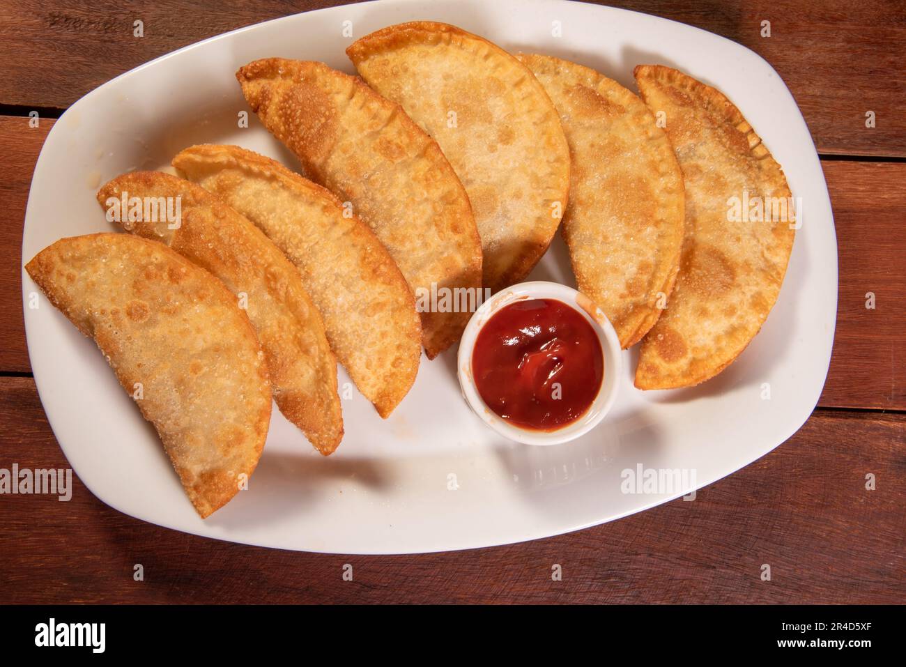 Fried Pastries, Pastel Frito Brasileiro, on wooden table. Pastel de ...