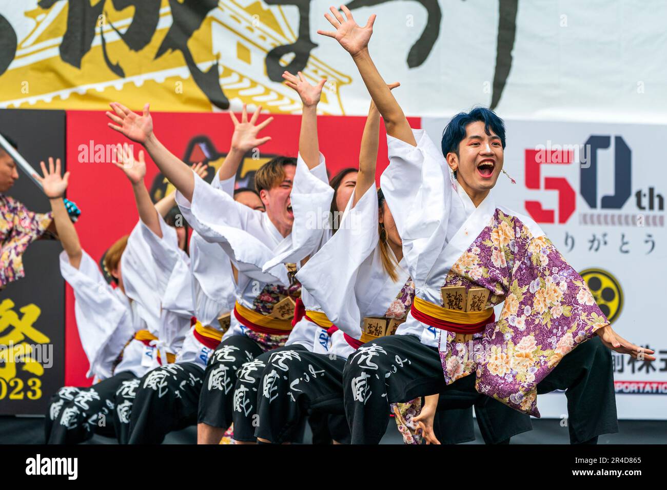 Row of Japanese Yosakoi dancers dancing on stage at Kyusyu Gassai festival in Kumamoto. Wearing ...