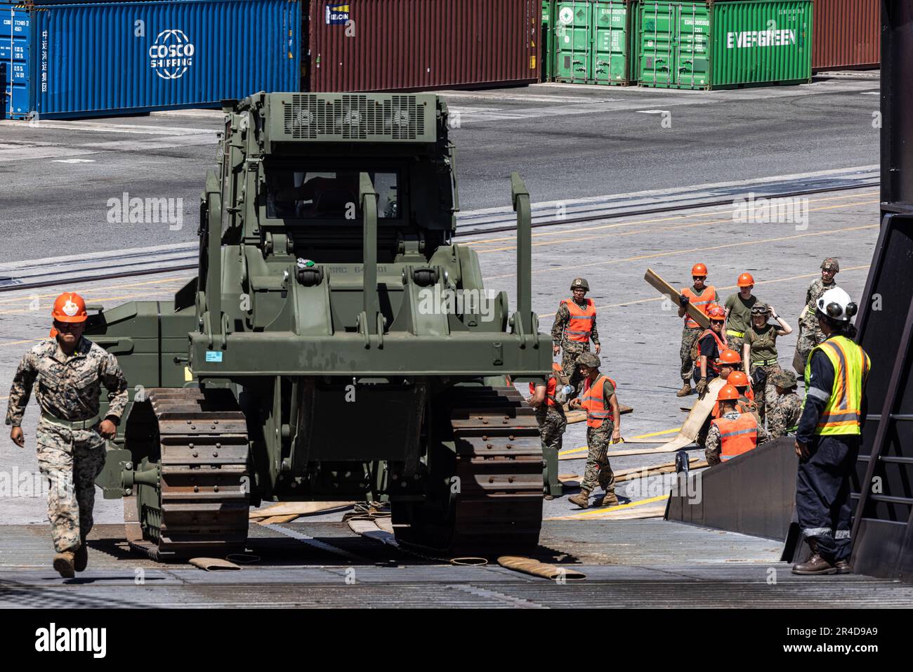 U.S. Marines with 3rd Landing Support Battalion guide an 1150E Medium ...