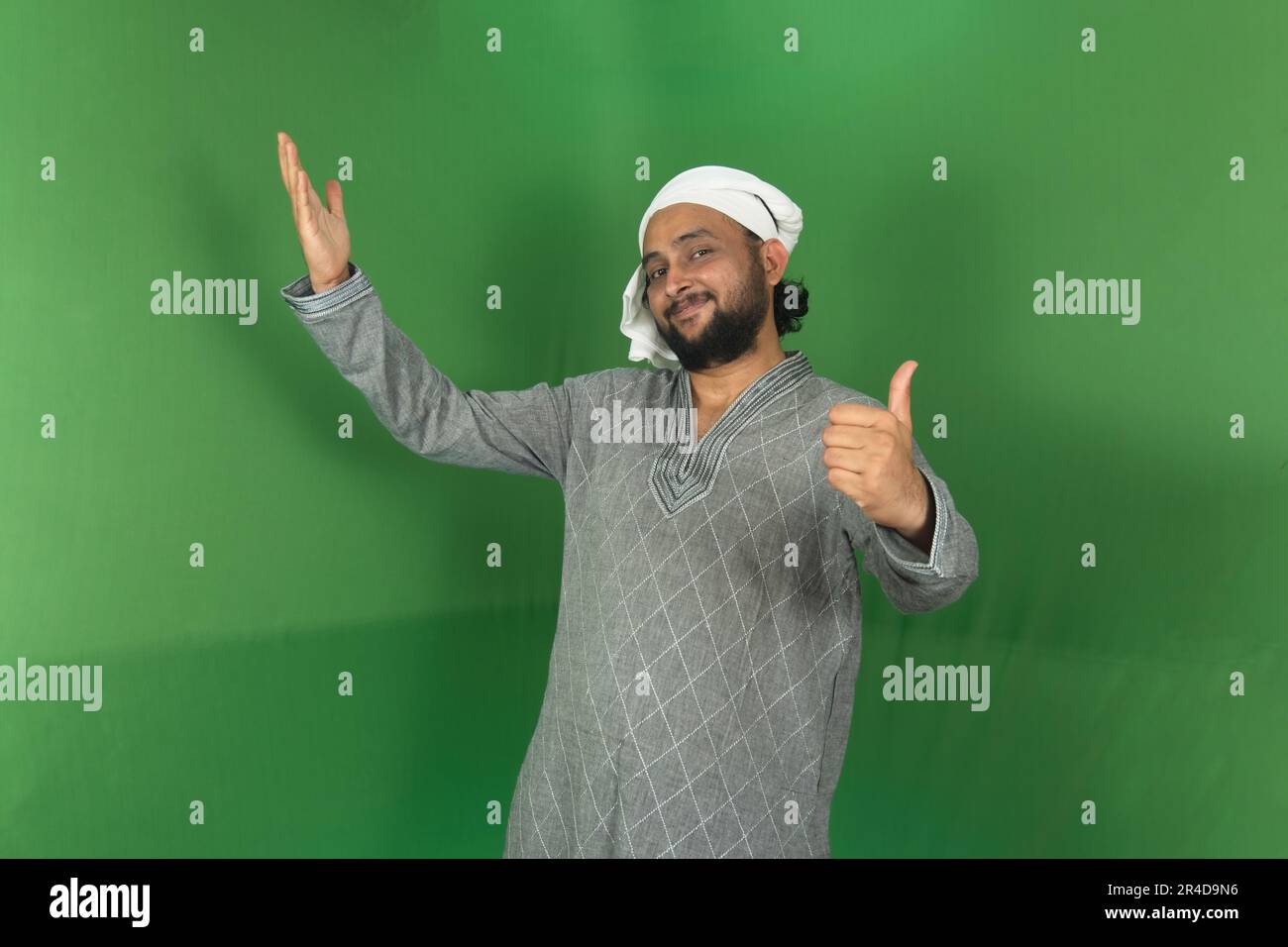Young Indian farmer smiling and looking at camera, left hand thumbs up ...