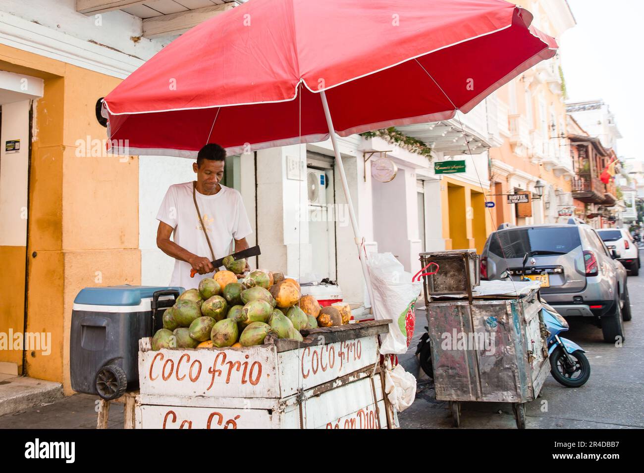 A man sells coco frio coconut water from a street cart in Cartagena ...