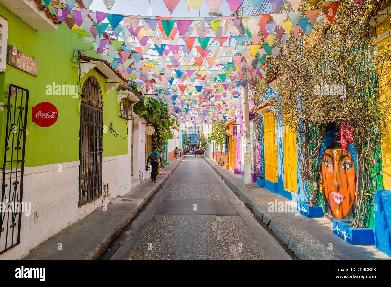 Looking down a street with pennant flags strung across brightly colored ...