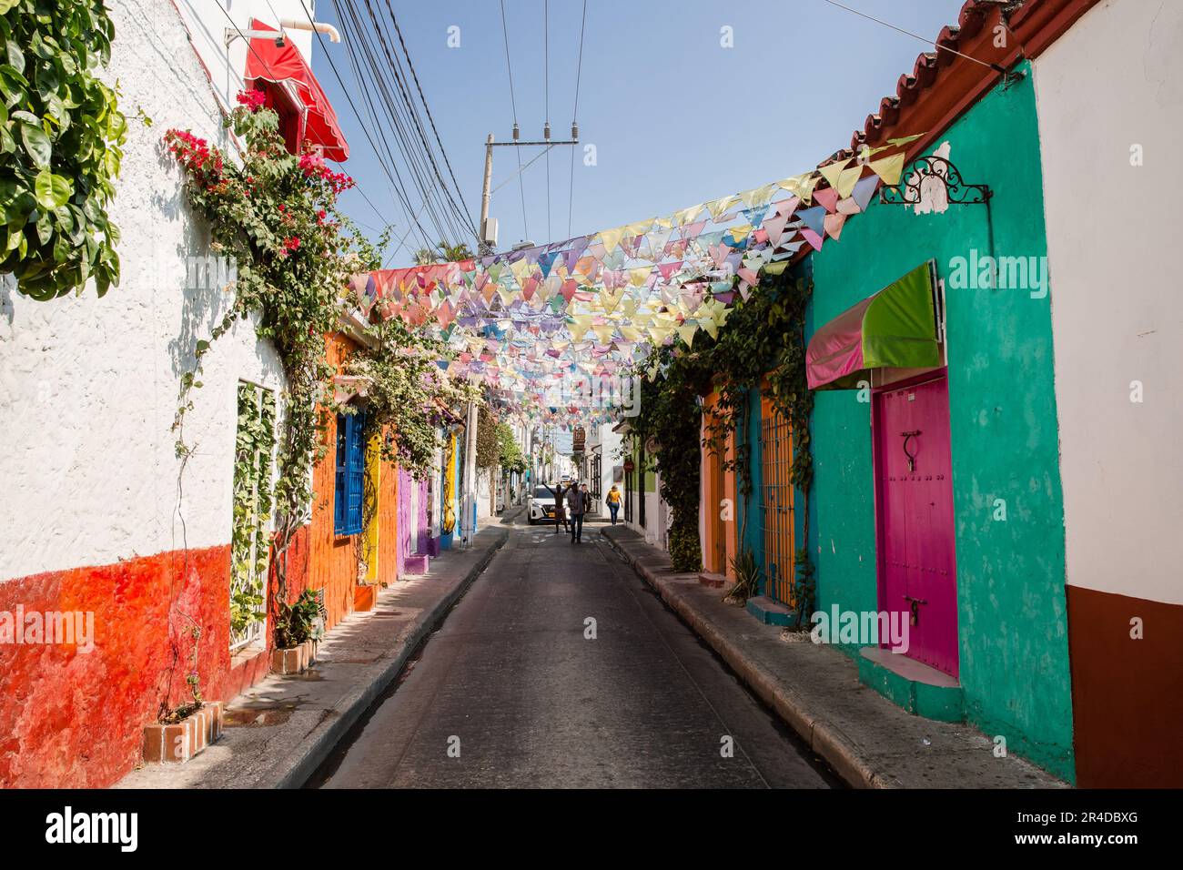 Looking down a street with pennant flags strung across brightly colored ...