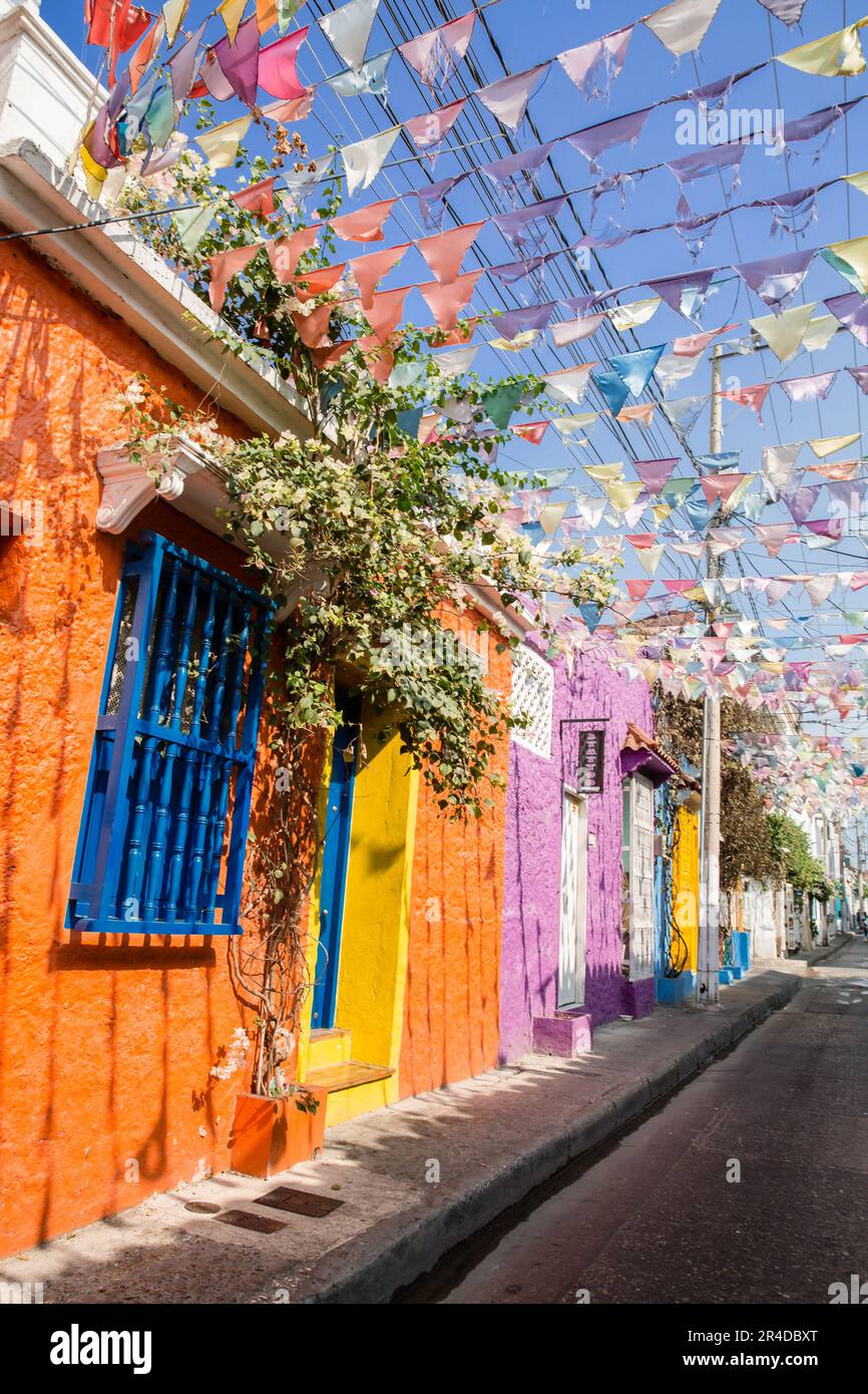 Looking down a street with pennant flags strung across brightly colored ...
