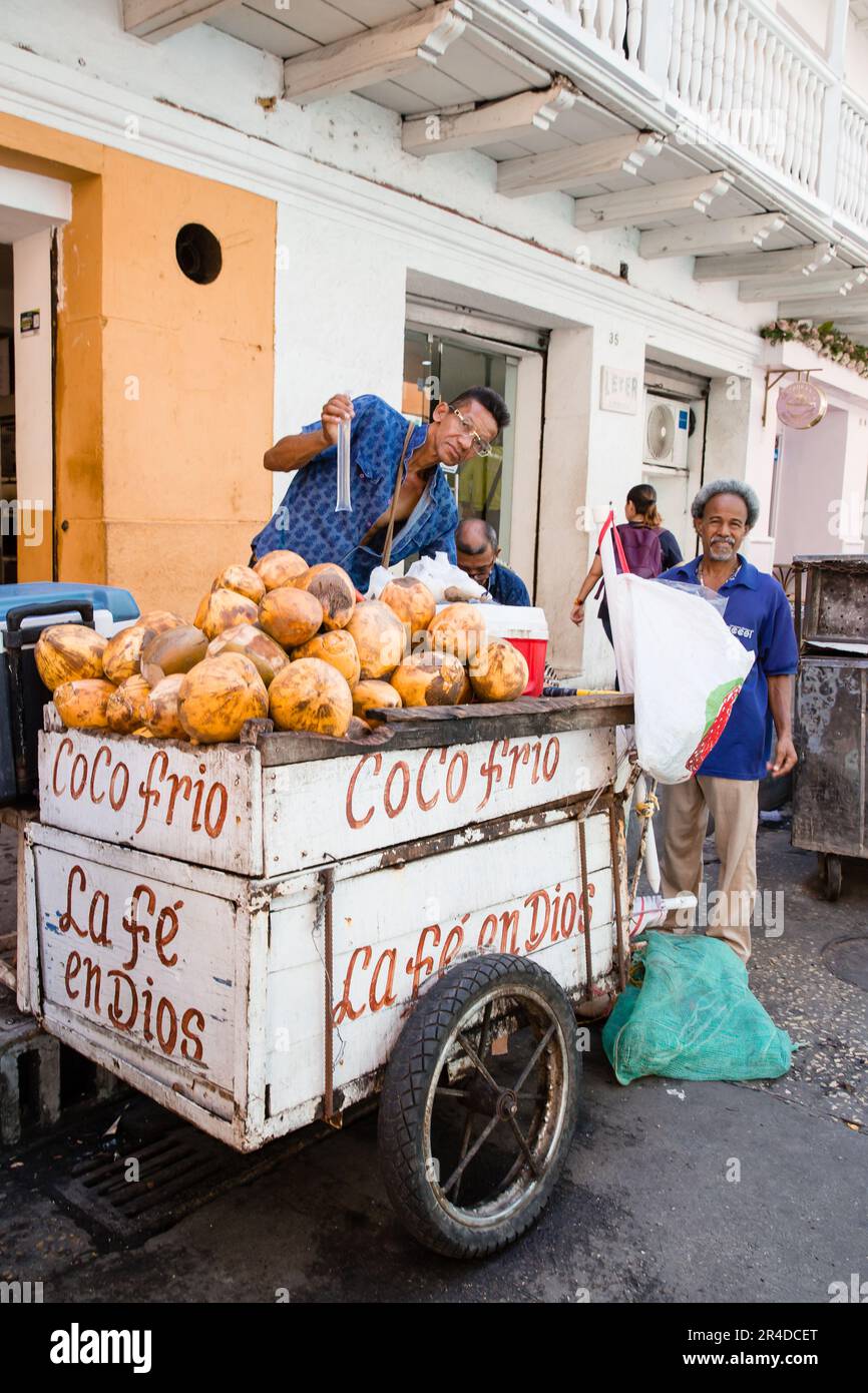 A man sells coco frio coconut water from a street cart in Cartagena ...