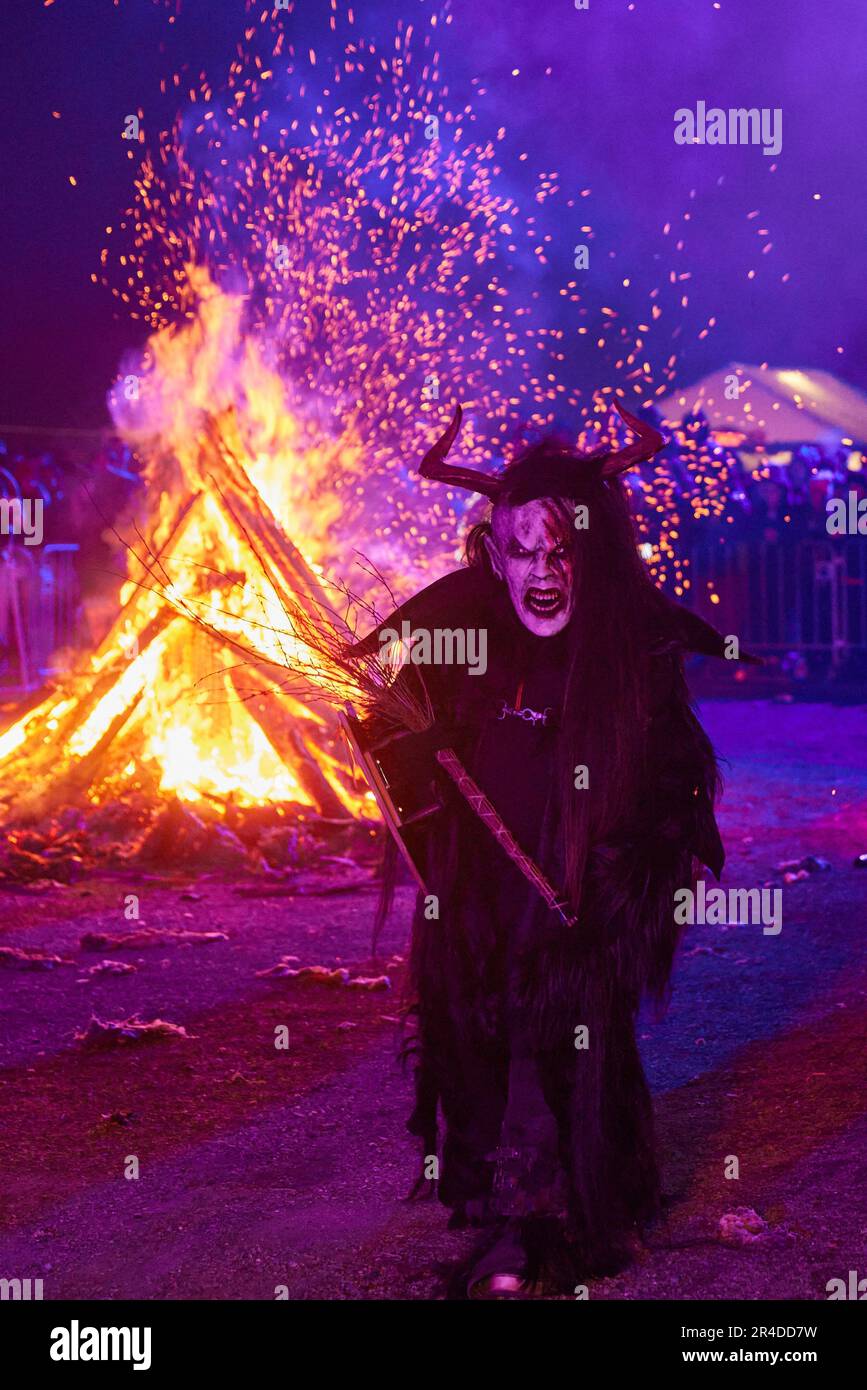A young female adult wearing a black outfit is walking by an open fire ...