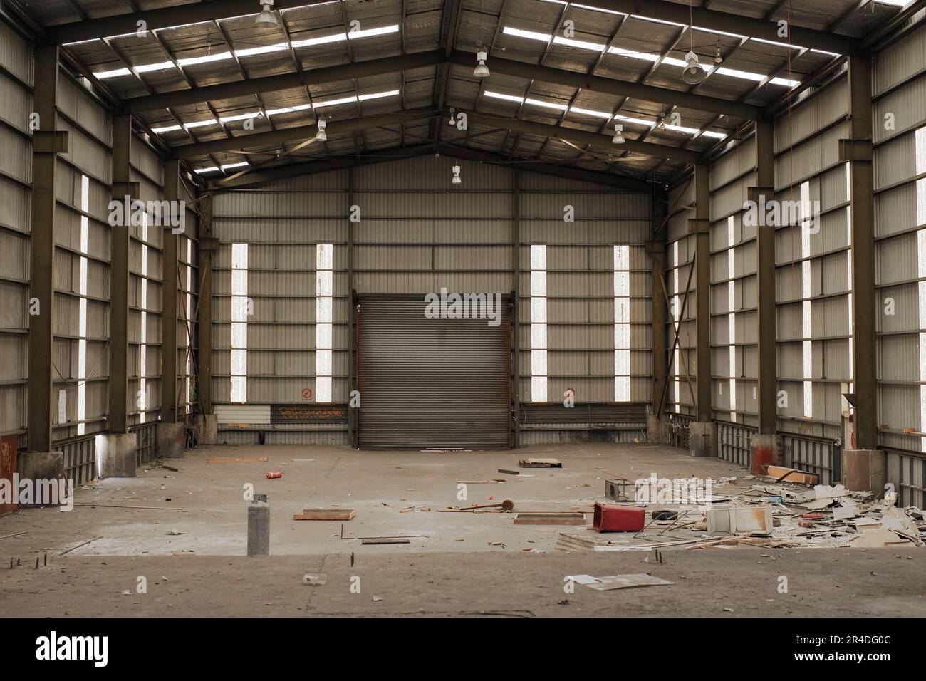 This spacious, empty warehouse boasts an impressive exposed ceiling and ...