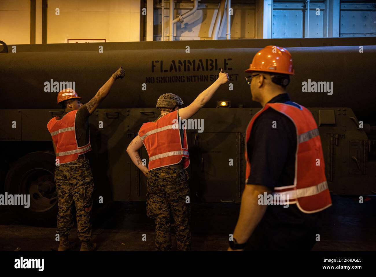 U.S. Marines with 3rd Landing Support Battalion guide an M970 Semi ...