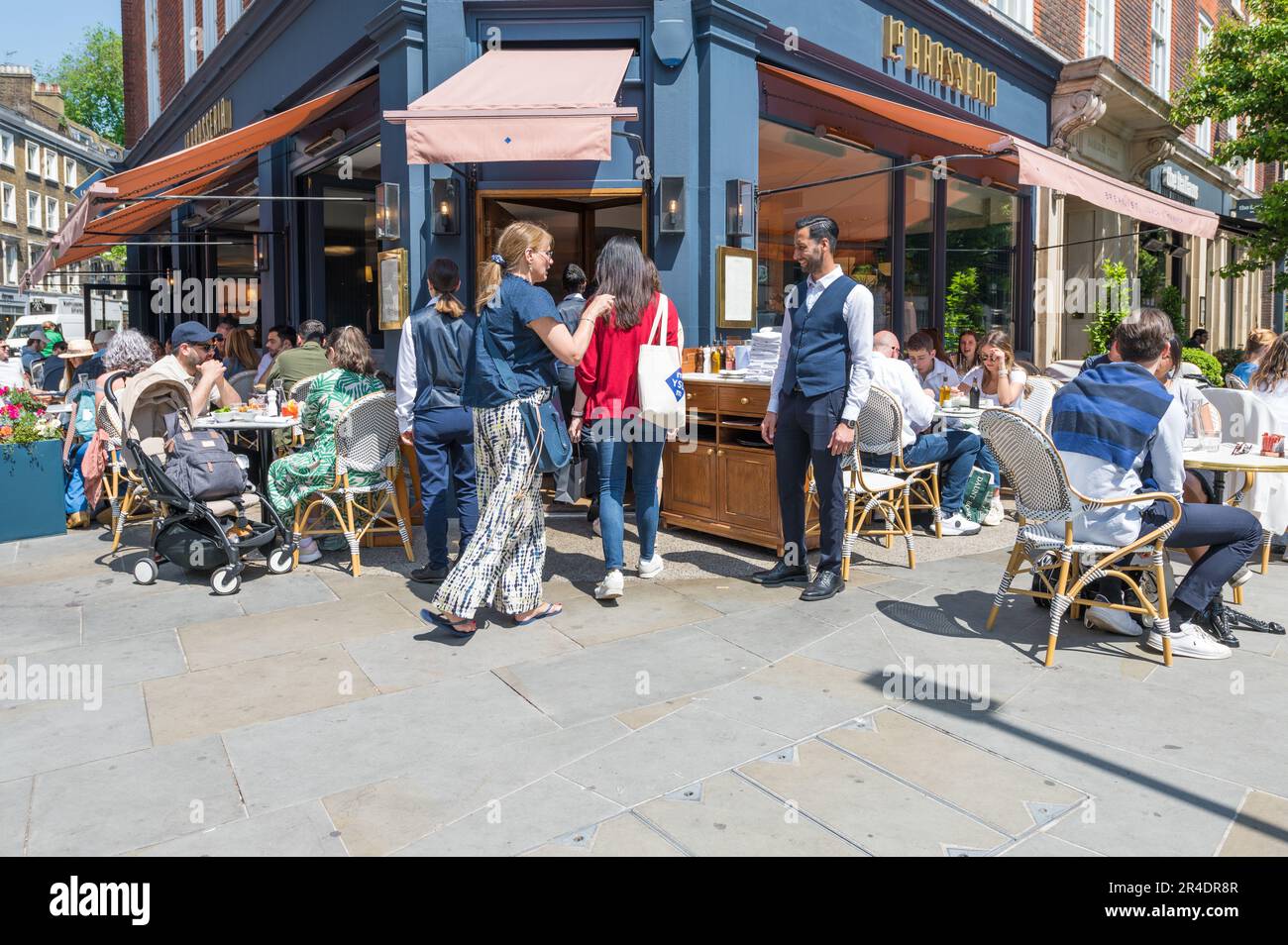 Waiter greets customers entering La Brasseria Milanese Italian ...
