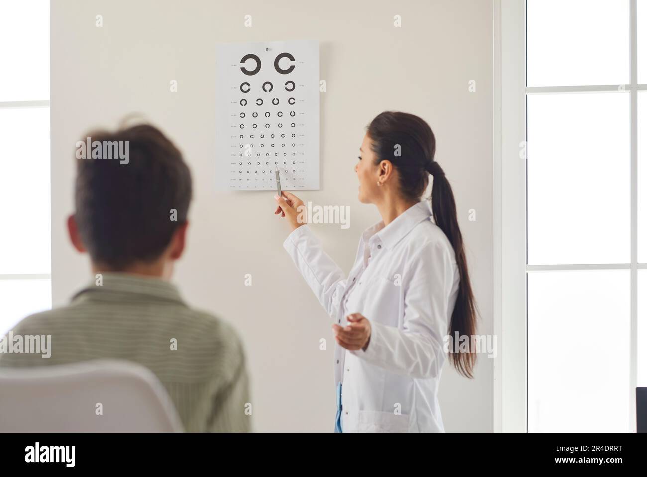 Female doctor testing vision of boy pointing to vision chart Stock ...