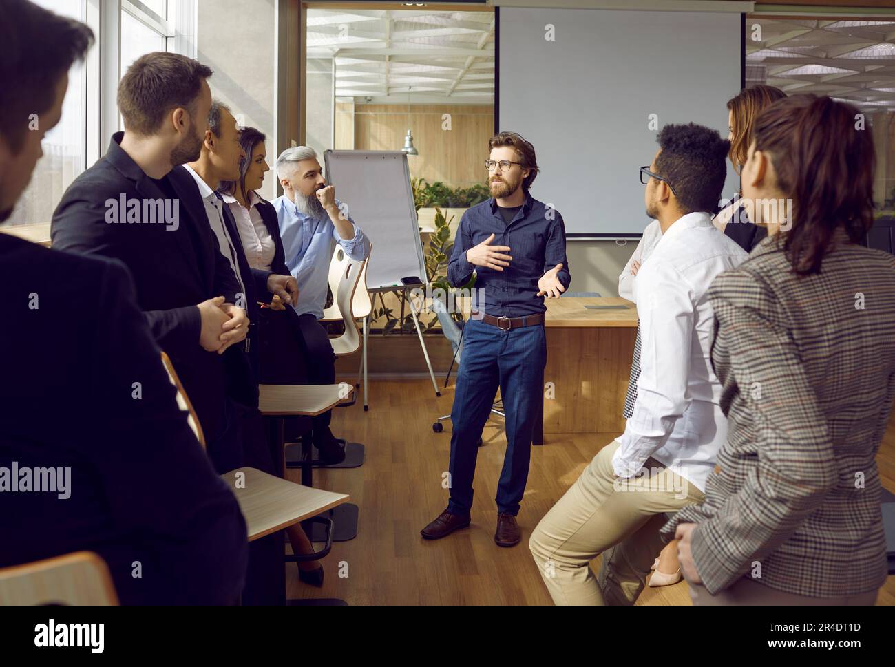 Serious man business trainer talking to group of people in office ...
