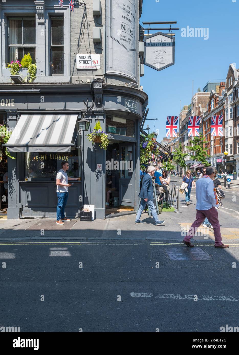 People out and about on a sunny day pass by The Marylebone public house ...