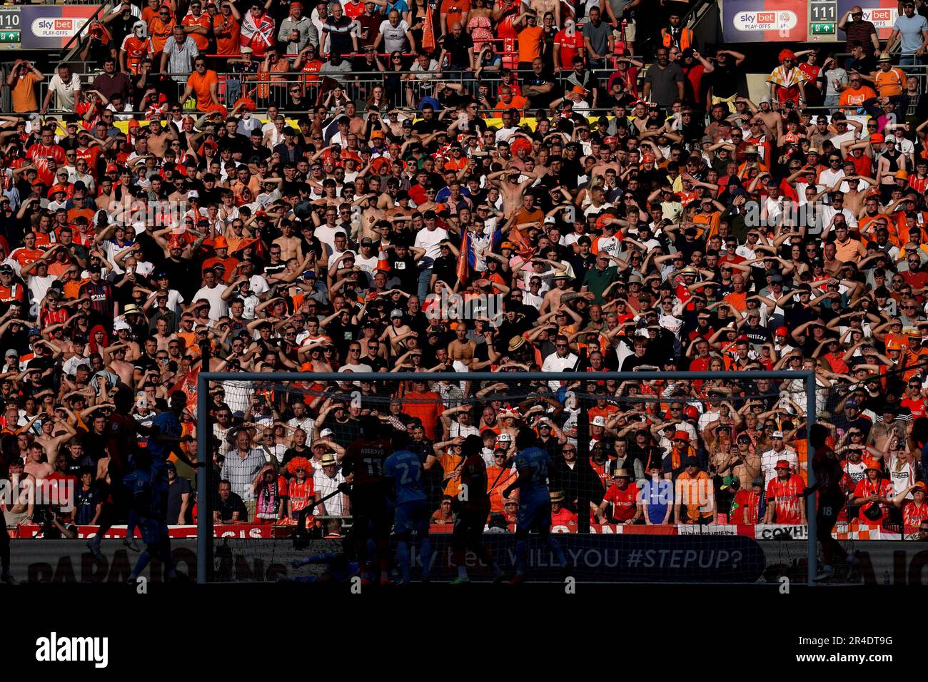 Luton Town fans in the stands shield their eyes from the sun during the ...