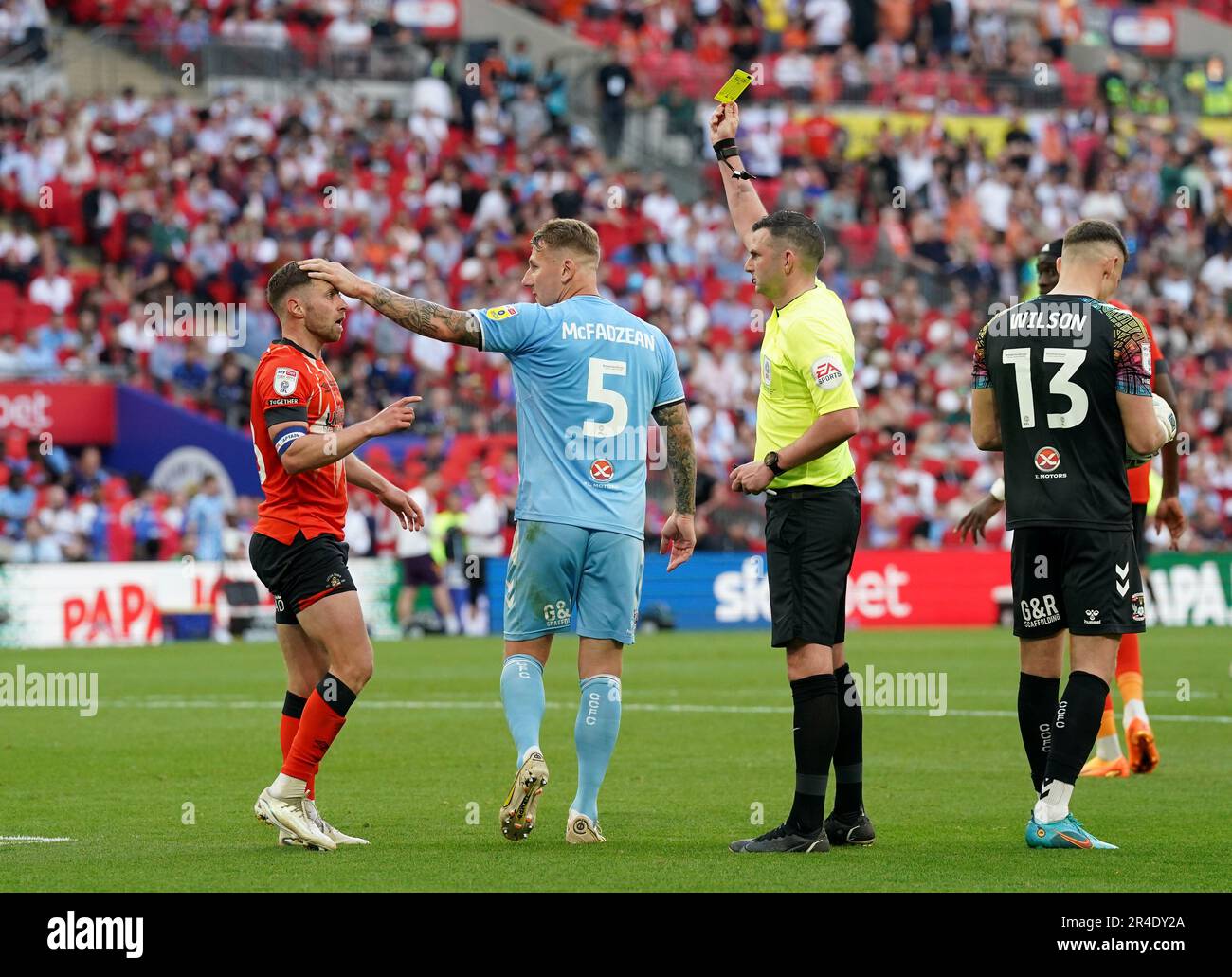 Luton Town's Jordan Clark (left) is shown a yellow card for simulation ...