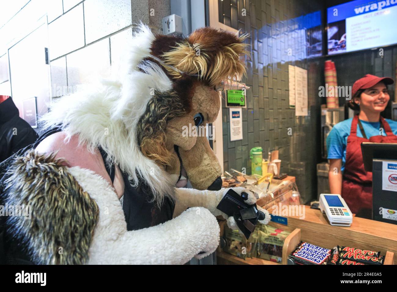 London, UK. 27th May, 2023. A visitor in furry outfit tries to pay for ...