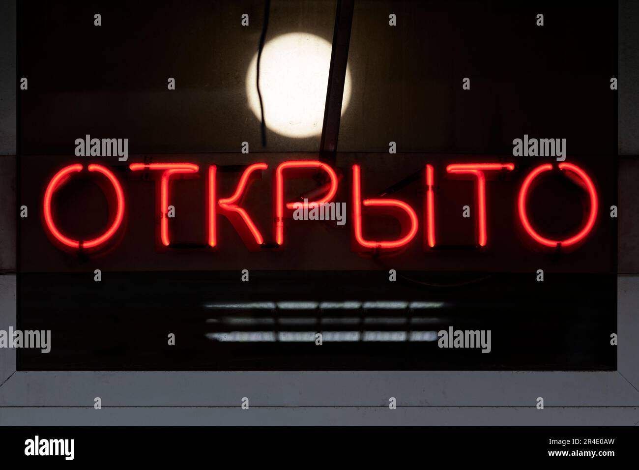 Red neon light shaped into the Russian word meaning "OPEN" in English ...