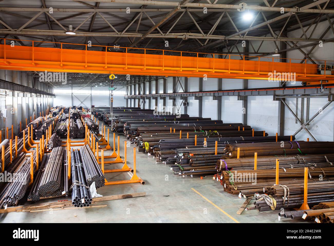 Pipes warehouse. Orange overhead crane and concrete floor Stock Photo ...