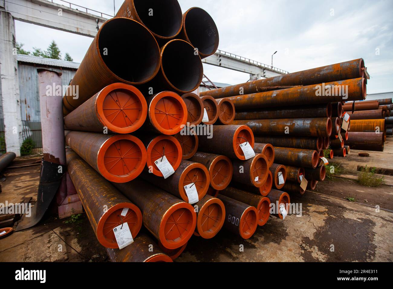 Rusted steel tubes with red plastic caps outdoor Stock Photo - Alamy