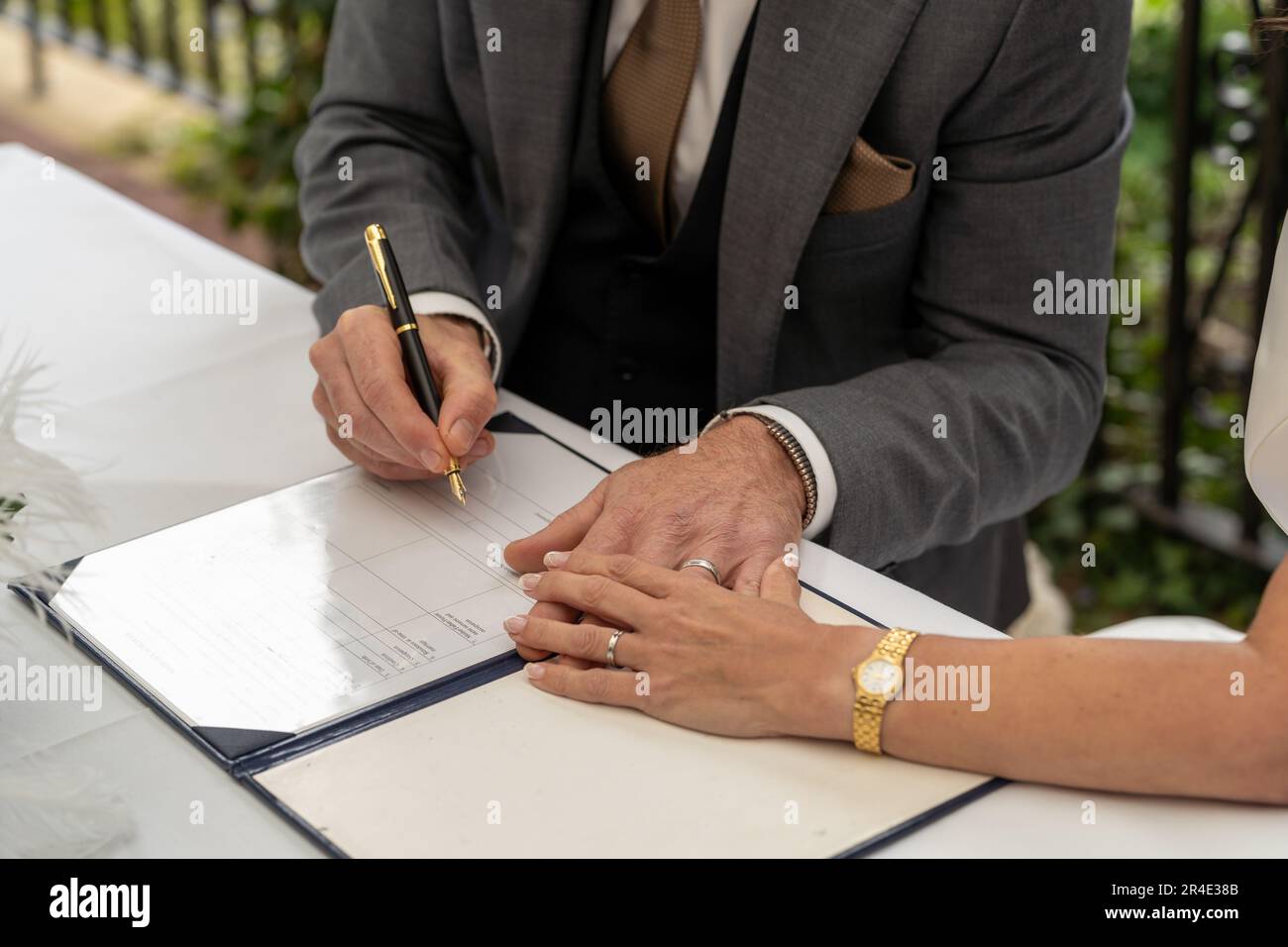 A happy couple sealing their union with a signature on their wedding ...