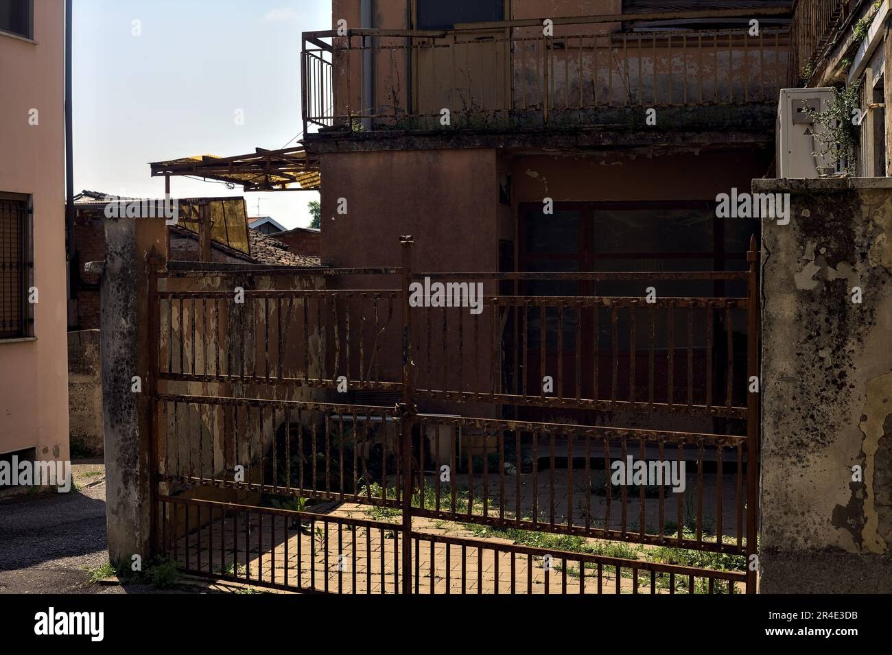 Abandoned warehouse blocked by gates in an alley on a sunny day in the ...