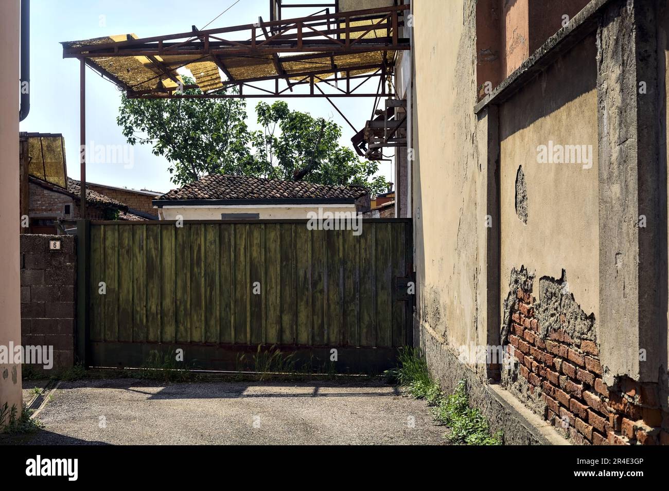 Abandoned warehouse blocked by gates in an alley on a sunny day in the ...