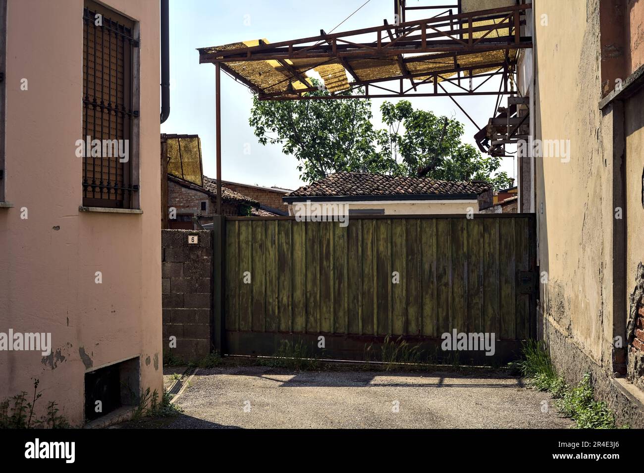 Abandoned warehouse blocked by gates in an alley on a sunny day in the ...
