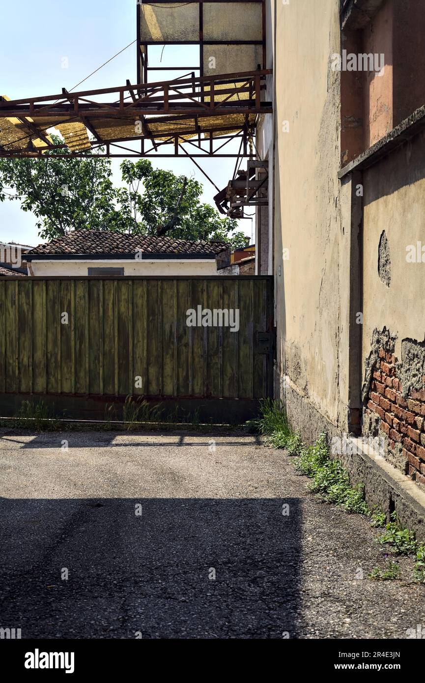 Abandoned warehouse blocked by gates in an alley on a sunny day in the ...